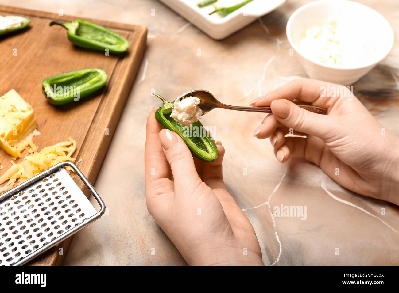 Woman cooking jalapeno poppers on color background Stock Photo - Alamy