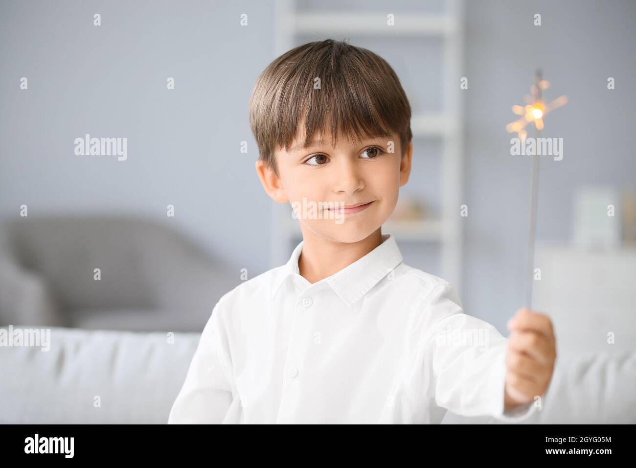 Little boy with sparkler at home Stock Photo - Alamy