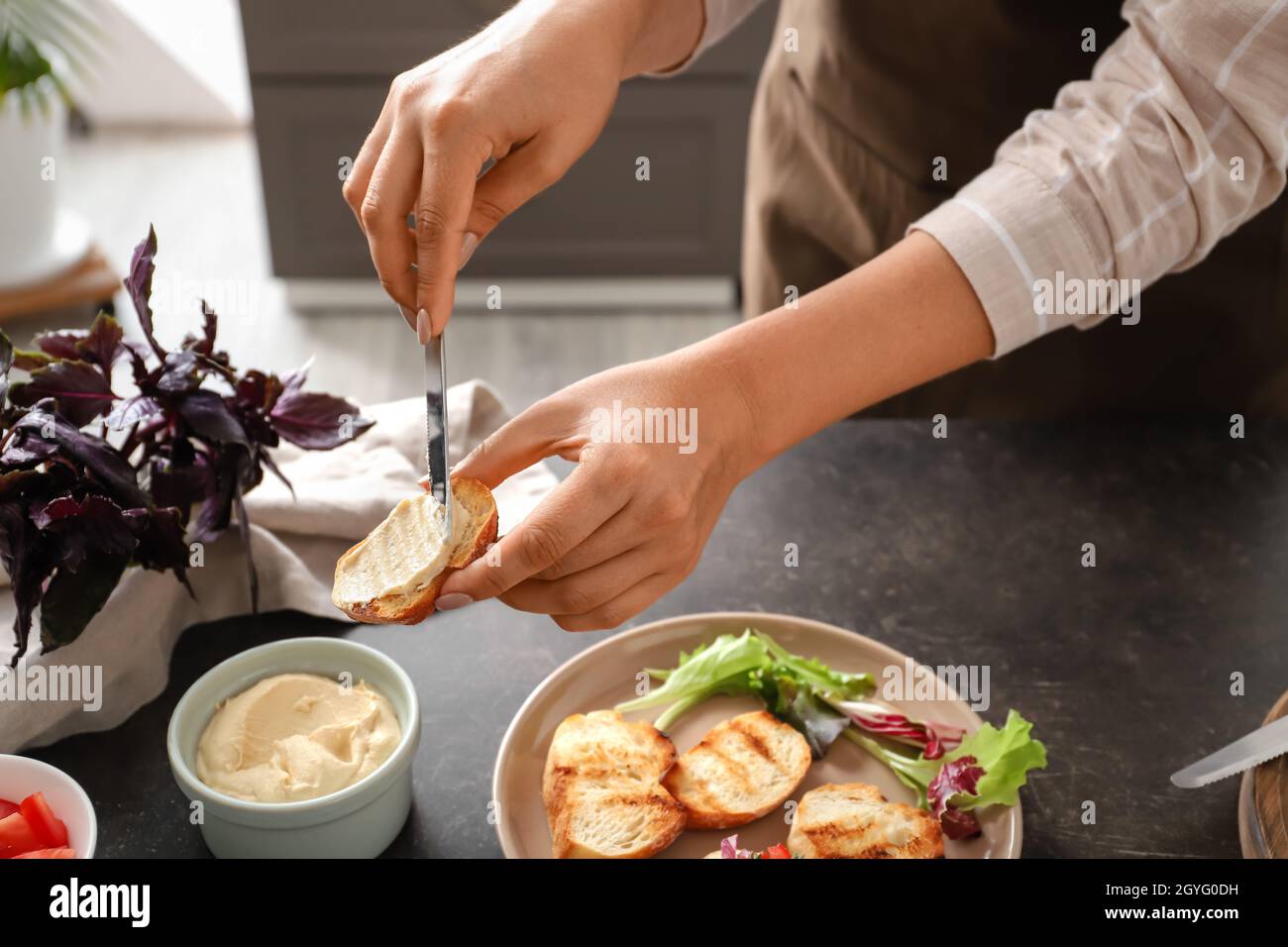 Woman eating vegetables with hummus hi-res stock photography and images ...