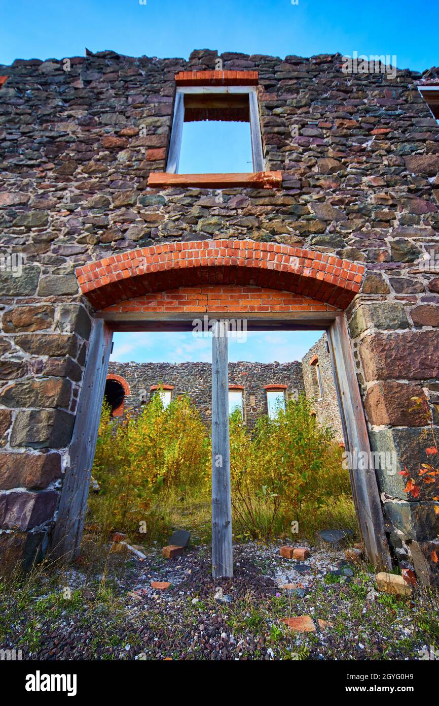Roofless abandoned building with red stone brick and multicolored stone ...