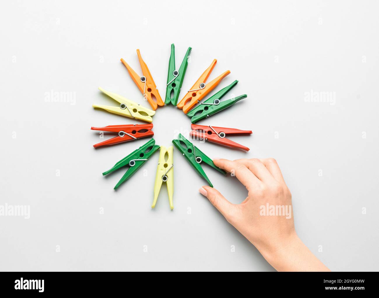 Female hand and plastic clothespins on grey background Stock Photo - Alamy