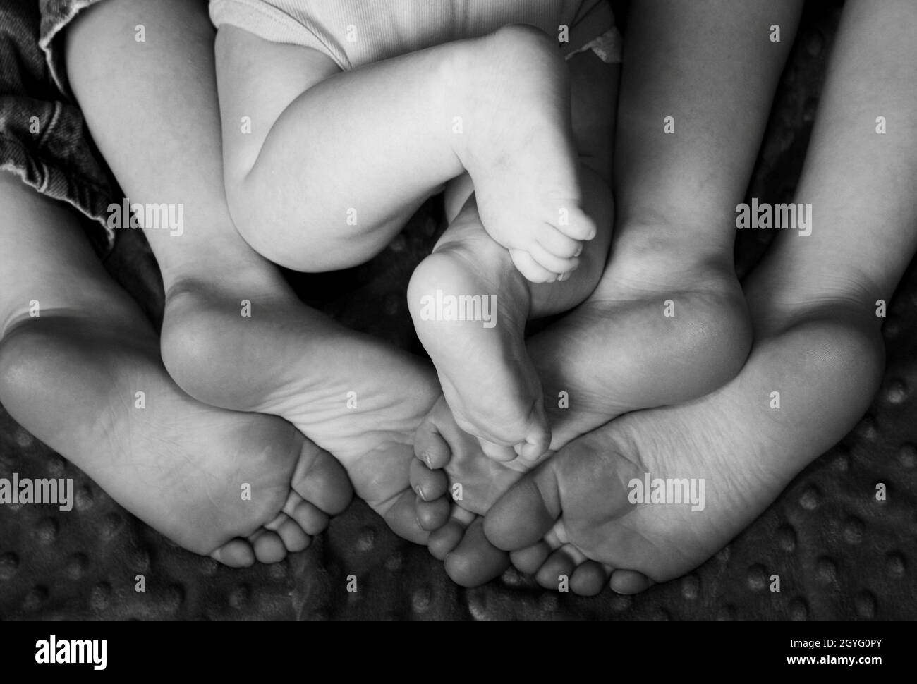 Feet of two children and one baby, black and white Stock Photo - Alamy
