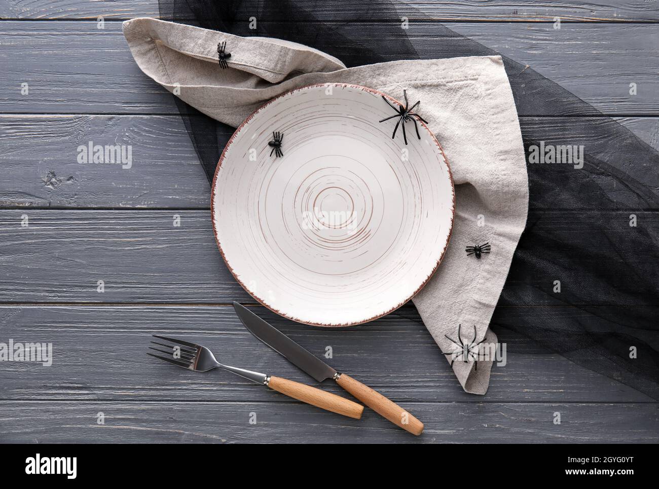 Halloween table setting with spiders on grey wooden background Stock ...