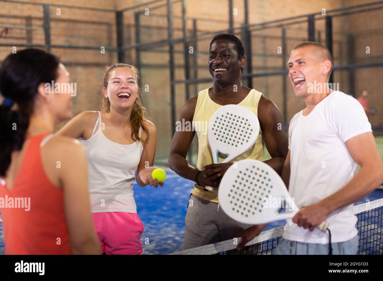 Two happy couples after playing padel on tennis court Stock Photo - Alamy