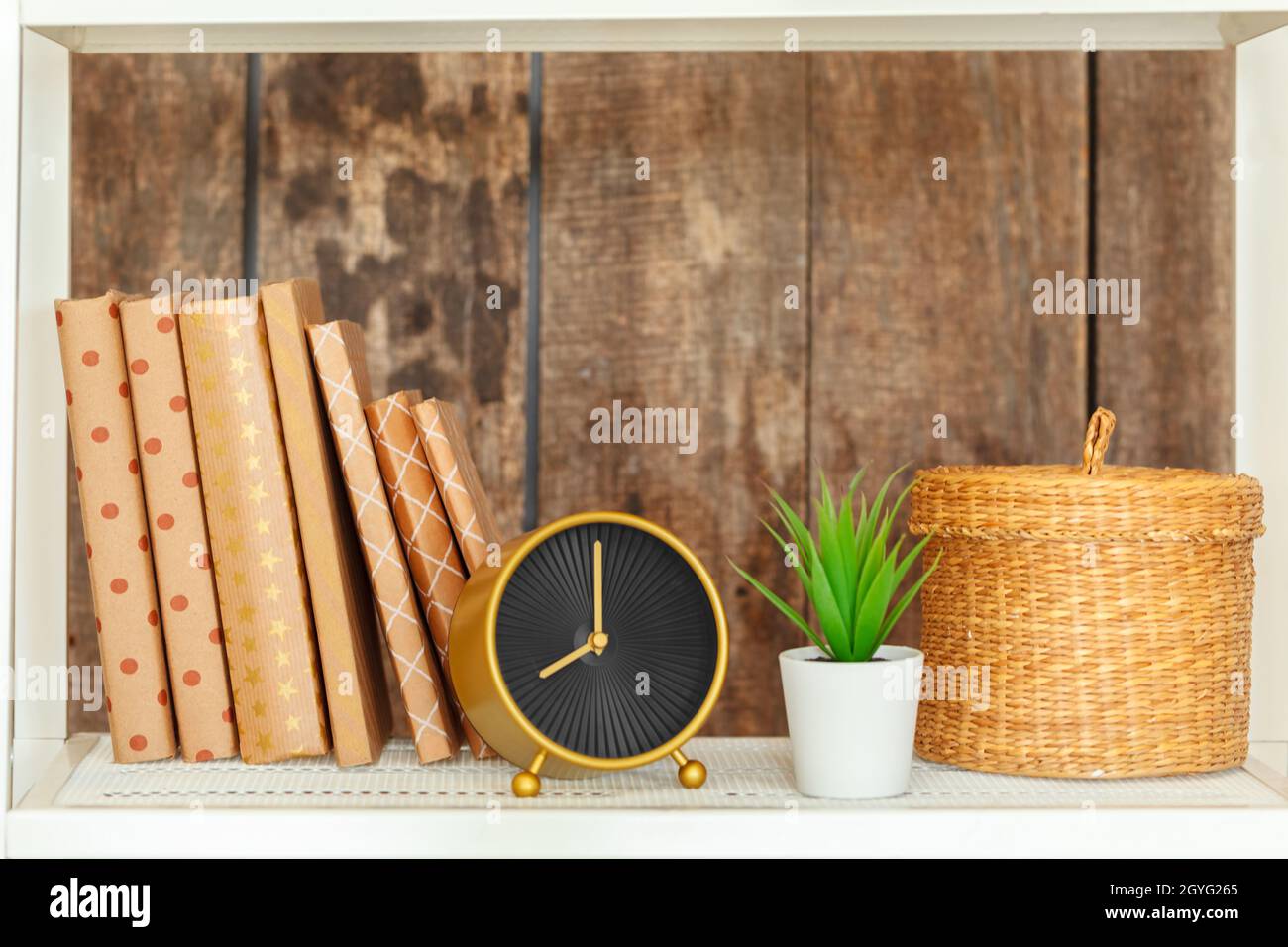 Stylish white bookshelf against grunge wooden wall Stock Photo - Alamy