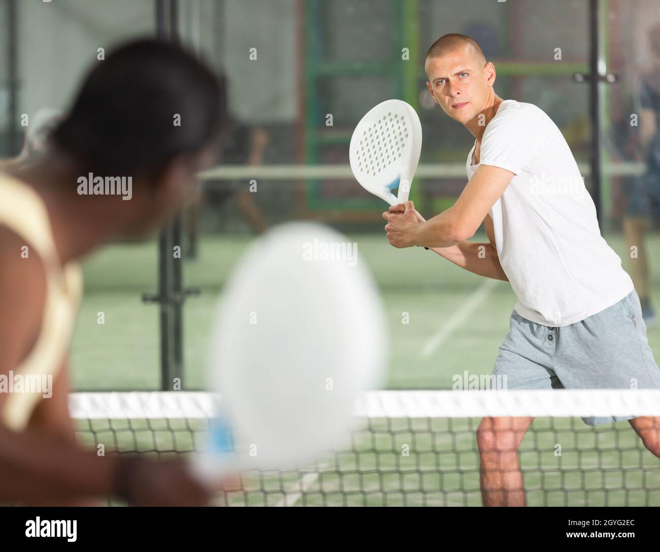 Focused padel player hitting two handed backhand in close court Stock ...