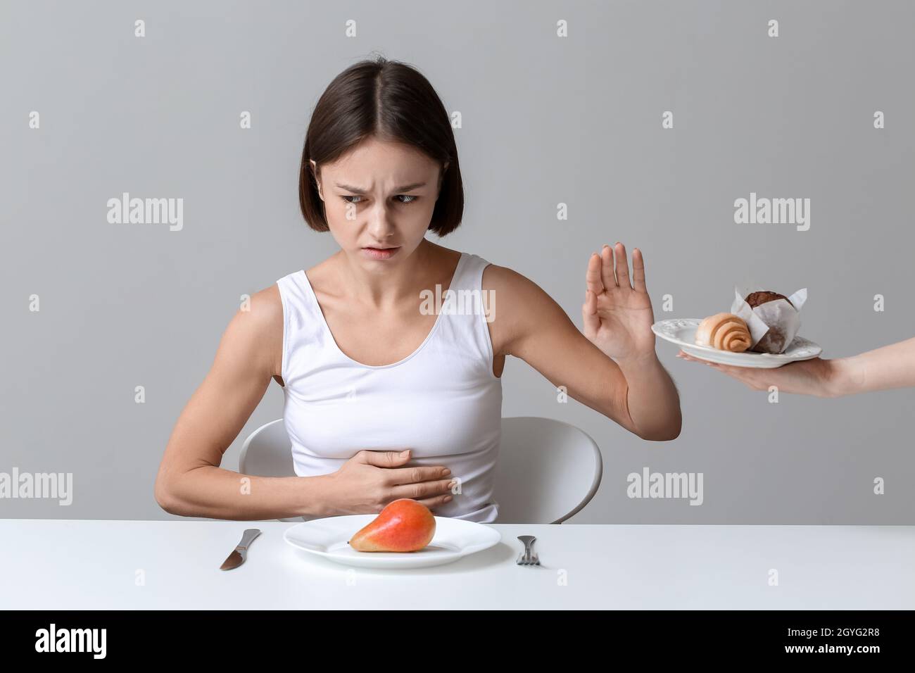Young woman refusing from food on grey background. Anorexia concept ...