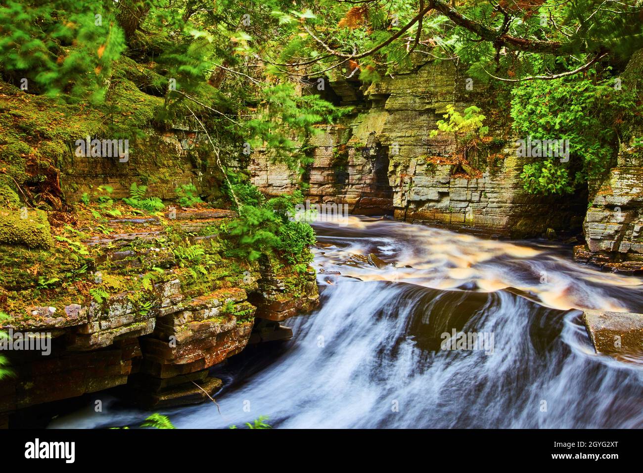 Flowing river with swirling pools of water and cliffs stacked like ...