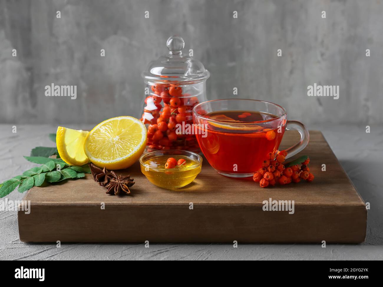 Composition with glass cup of tasty rowan tea, honey and lemon on ...