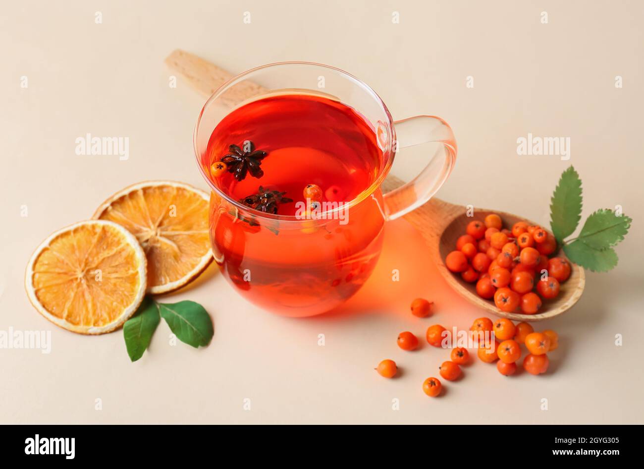 Glass cup of hot rowan tea and berries on color background Stock Photo ...
