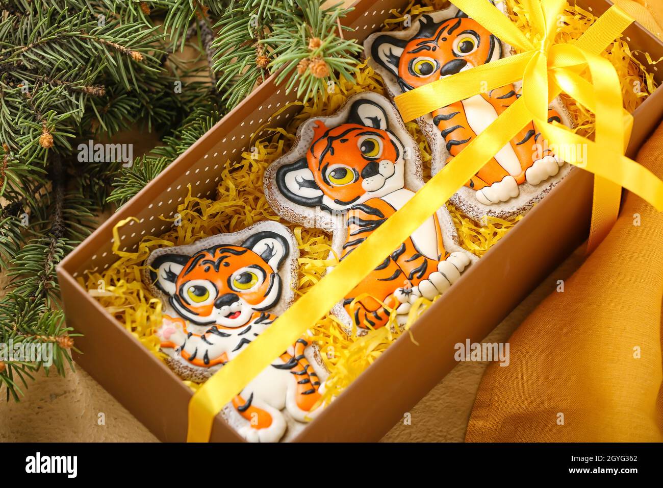 Box with cute cookies in shape of tiger for New Year 2022 on color ...
