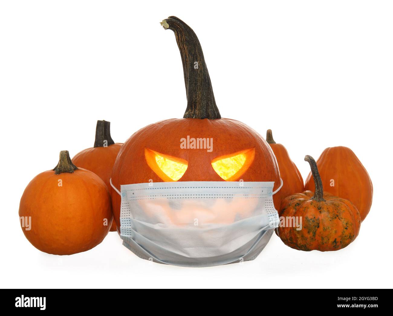 Carved and whole pumpkins for Halloween with medical mask on white ...
