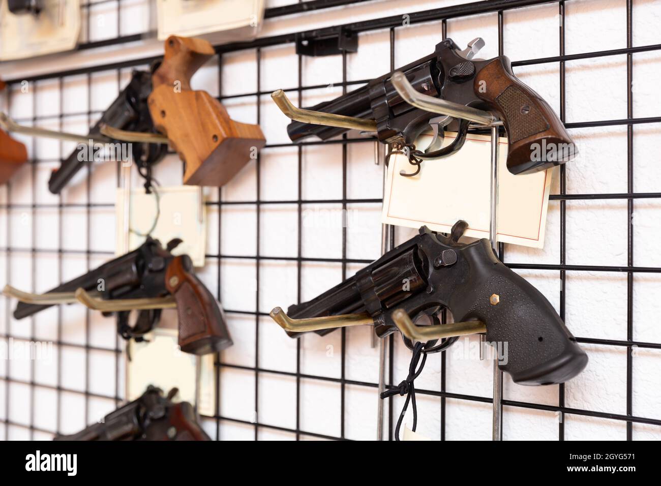 Gun shop with revolvers and pistols on showcase Stock Photo - Alamy