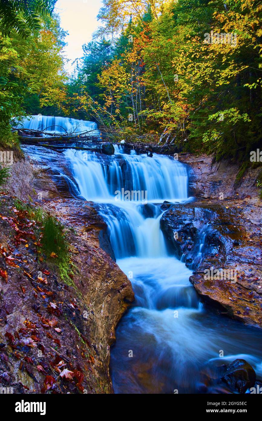 Four-tiered waterfall with smooth flowing white water and nearly baren ...
