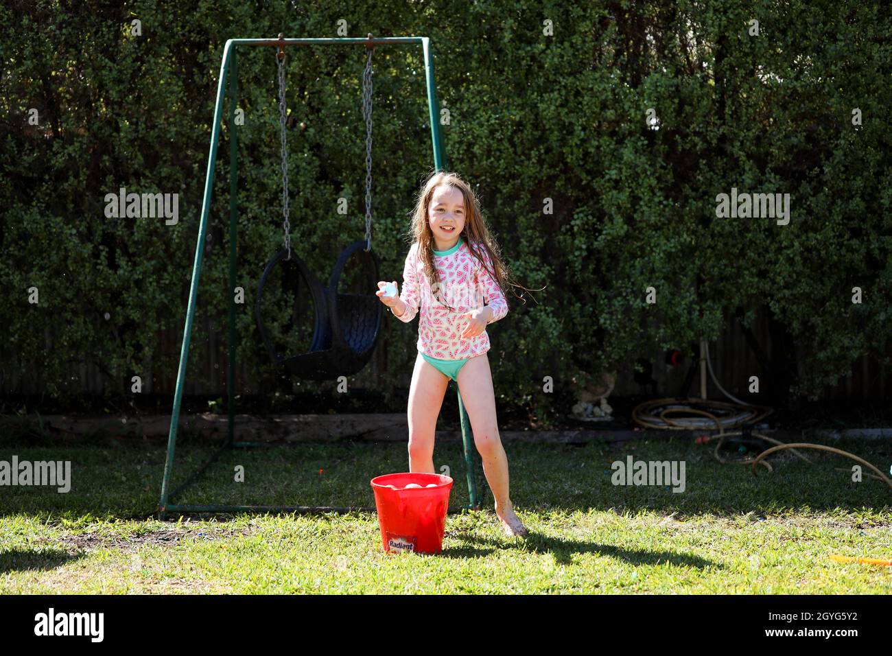 Aussie kids enjoying backyard water fight in summer Stock Photo - Alamy