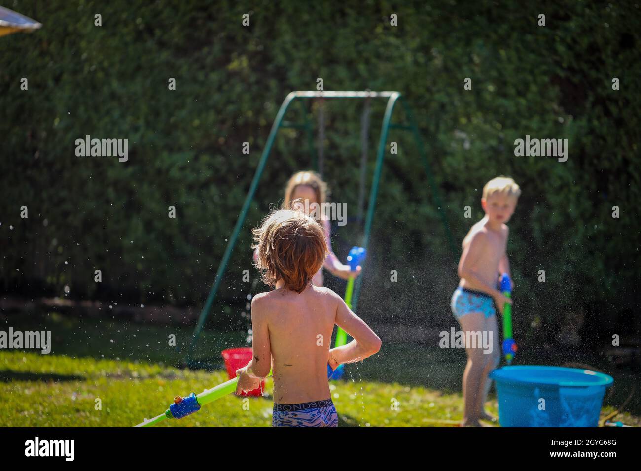Aussie kids enjoying backyard water fight in summer Stock Photo - Alamy
