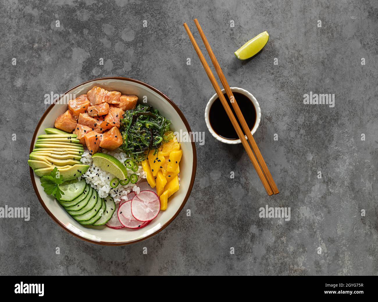 Salmon poke bowl with rice, mango, avocado, seaweed, radish, and ...