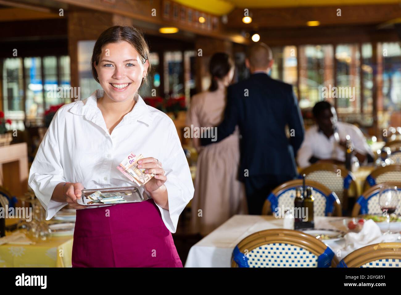 Waitress satisfied with good tip from guests Stock Photo - Alamy