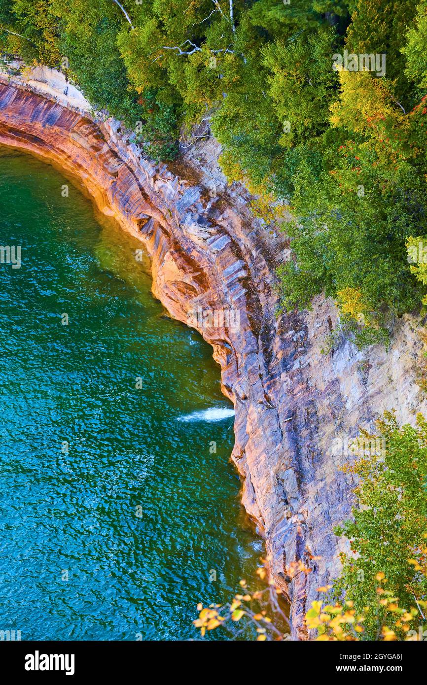 Colorful rocks overlook Michigan lake with choppy waters aerial shot ...