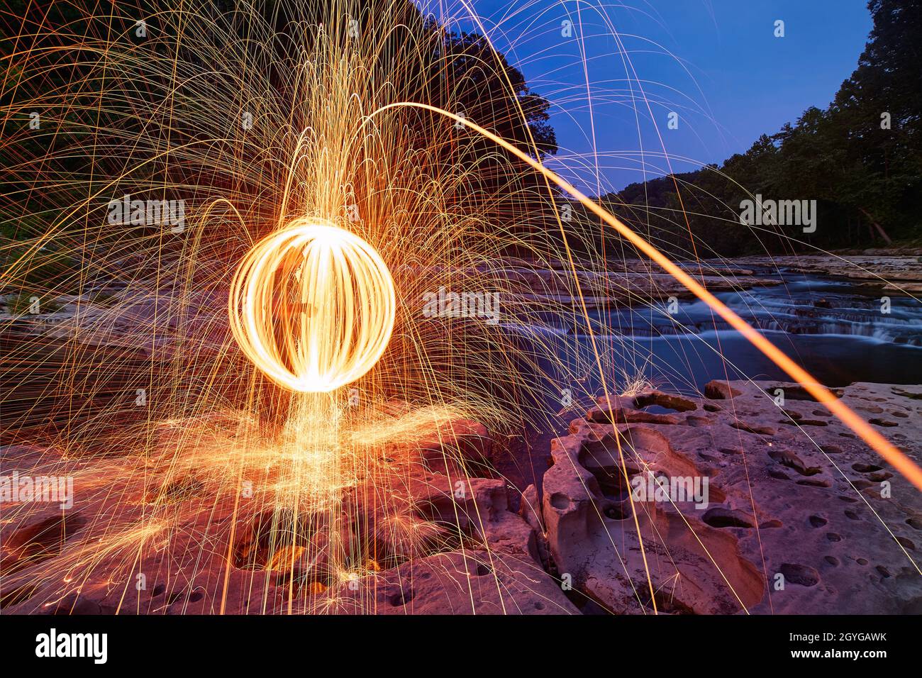 Yellow orbs of sparks flying into craggy stone and rock in front of ...