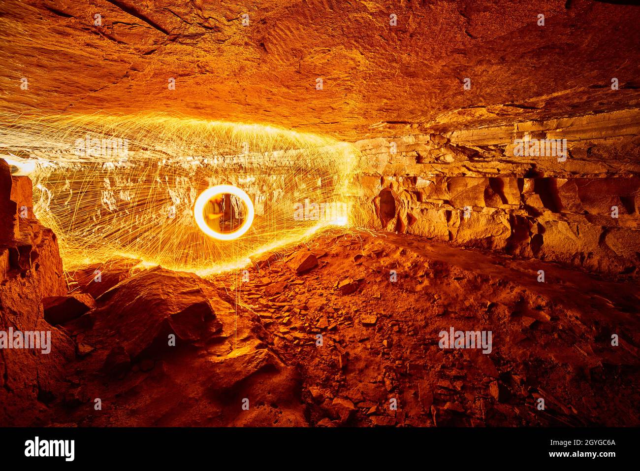 Shower of sparks and fire inside a cave creating a wall of fire over ...