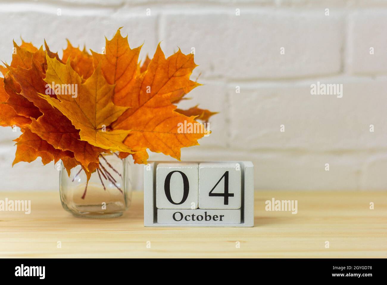 October 4 on the calendar and a bouquet of bright autumn leaves on the ...