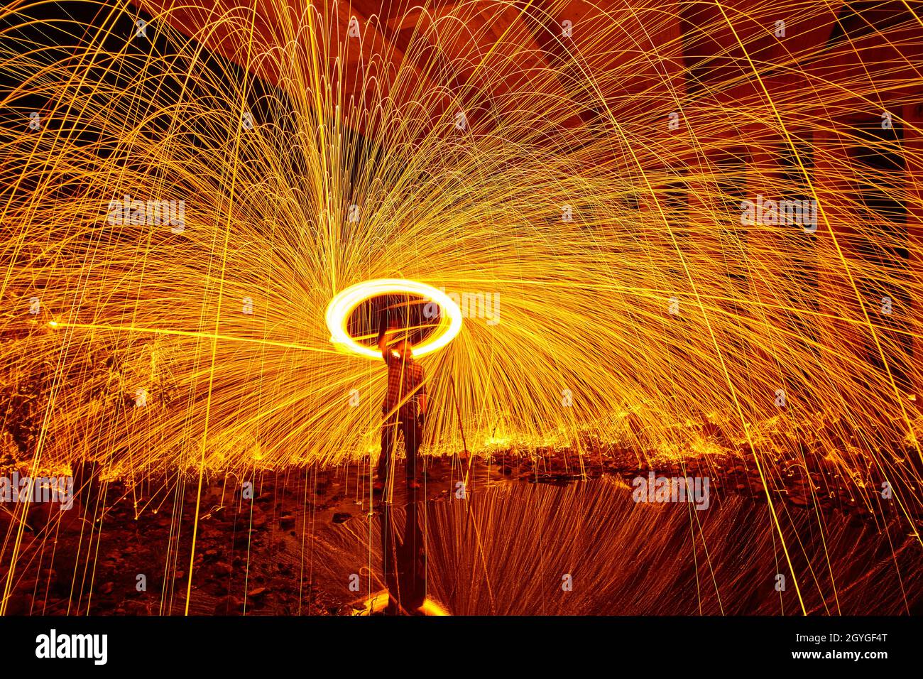 Shower of orange and yellow sparks with a lasso of light from steel ...