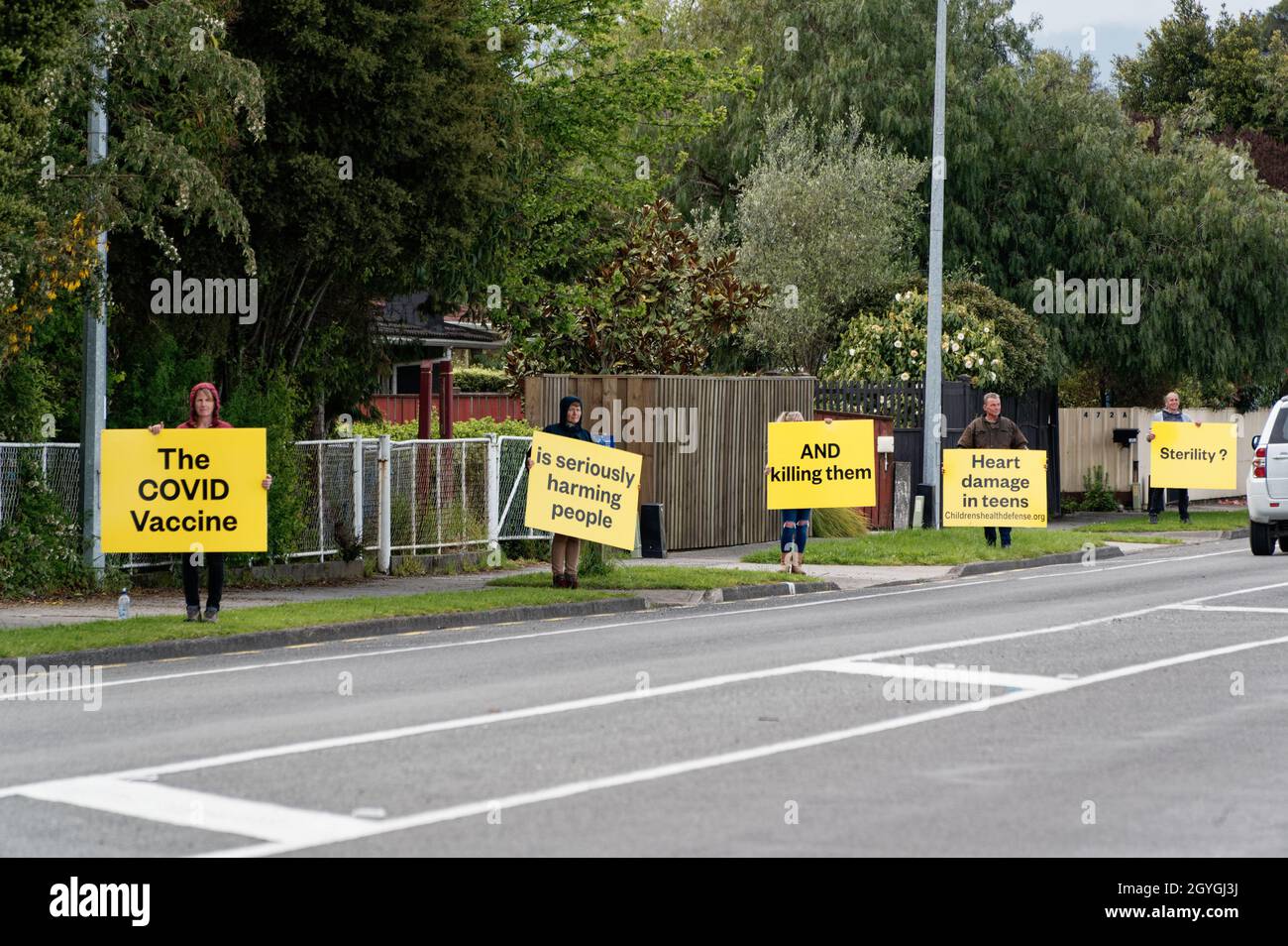 Anti vaccine protestors line the High Street in Motueka with signs ...