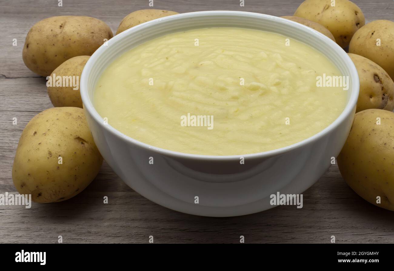 Mashed potatoes in small bowl decorated with raw potatoes Stock Photo ...