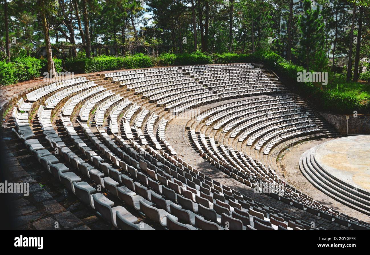 The rows of seats of an abandoned outdoor stage are slowly being ...