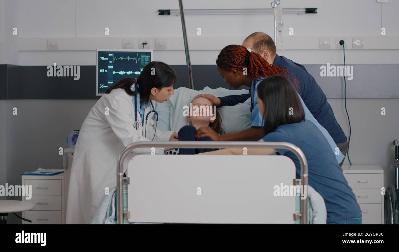 Pediatrician woman doctor holding sick little child monitoring disease ...