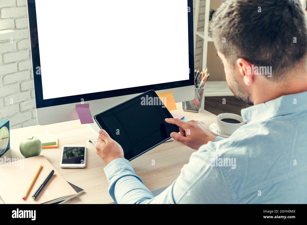 Office worker doing his job sitting at his working table with a ...