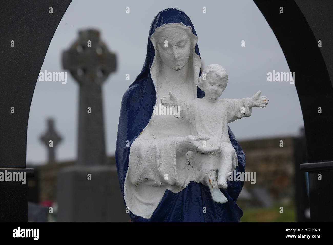 A holy statue of Mary and the infant Jesus in a graveyard on the west ...