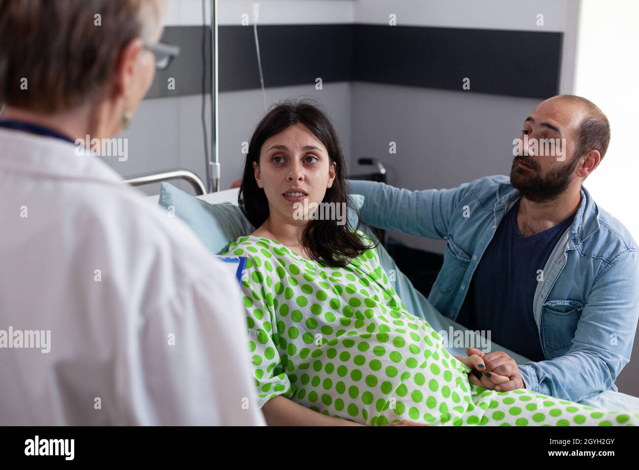 Obstetrics doctor talking to couple with pregnancy about childbirth ...