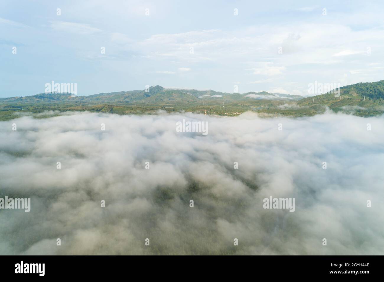 Aerial view drone shot of flowing fog waves on mountain tropical ...