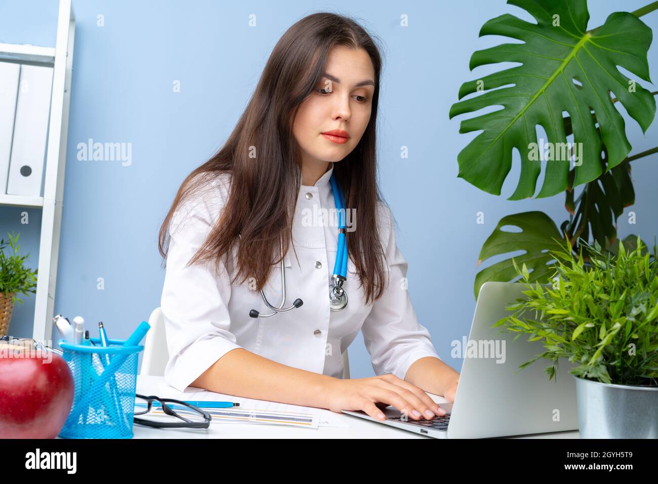 Young nice female doctor working in her office Stock Photo - Alamy
