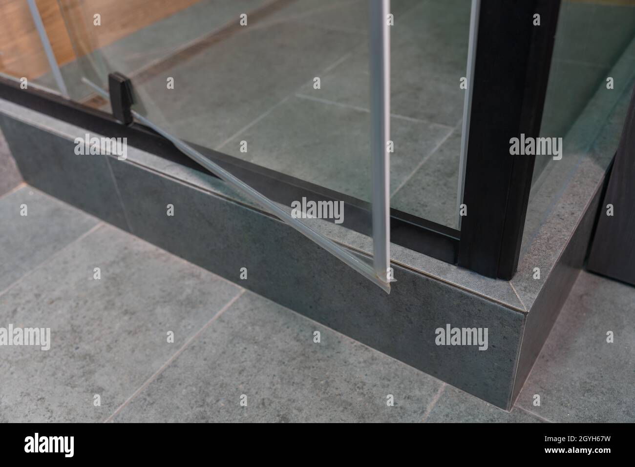 Open revolving glass door on a tiled shower cubicle in a low angle ...