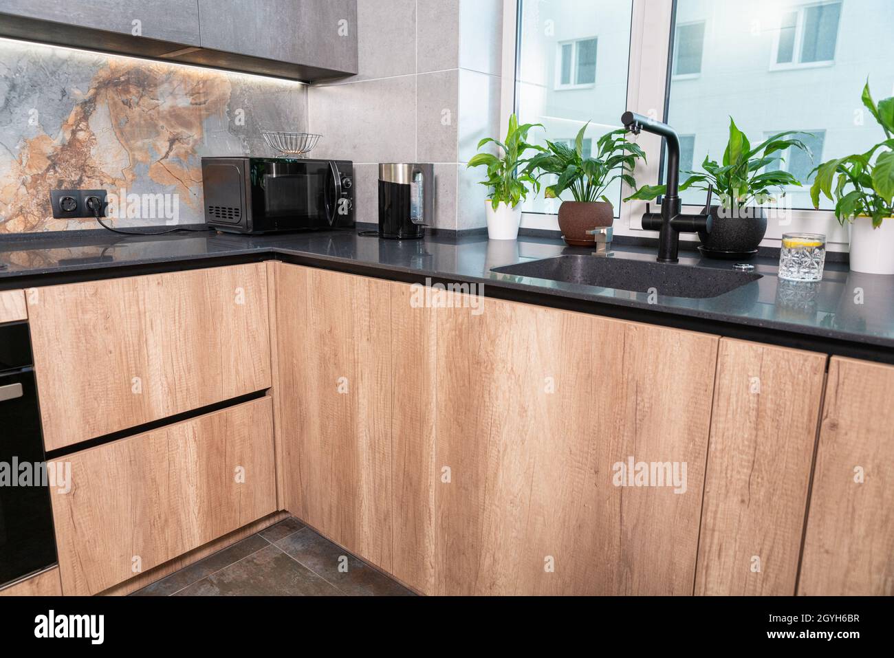 Interior of a modern fitted kitchen with stone decor and wooden ...