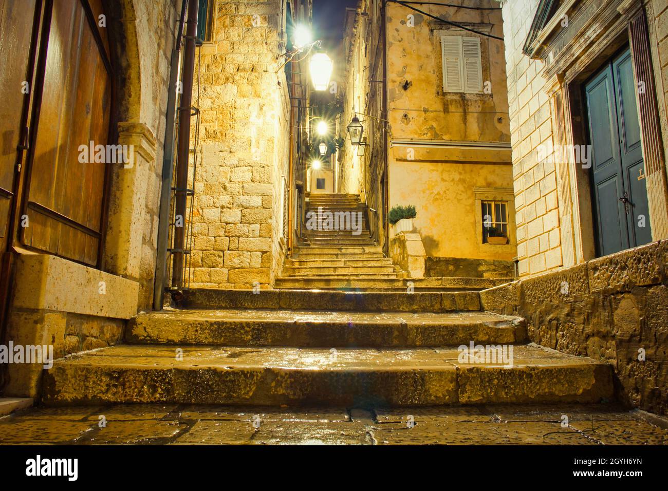Old staircase alleyway with bright lights through a building Stock ...