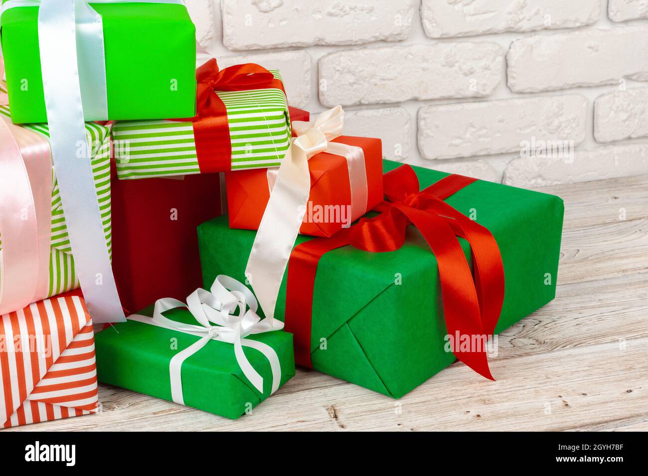Colorful gift boxes against white brick wall background Stock Photo - Alamy