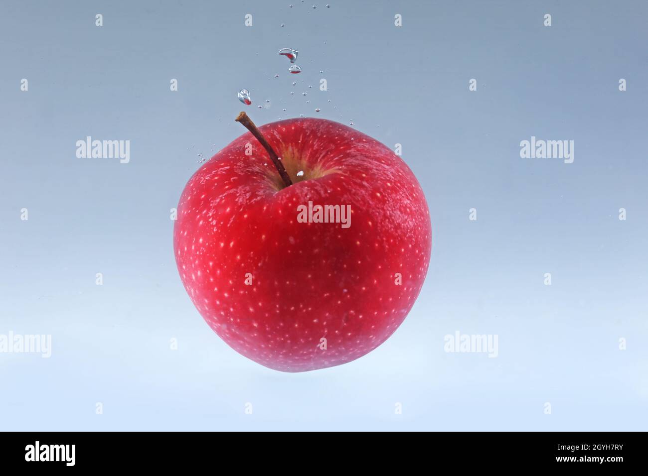 Apple falls into water on a light background Stock Photo - Alamy