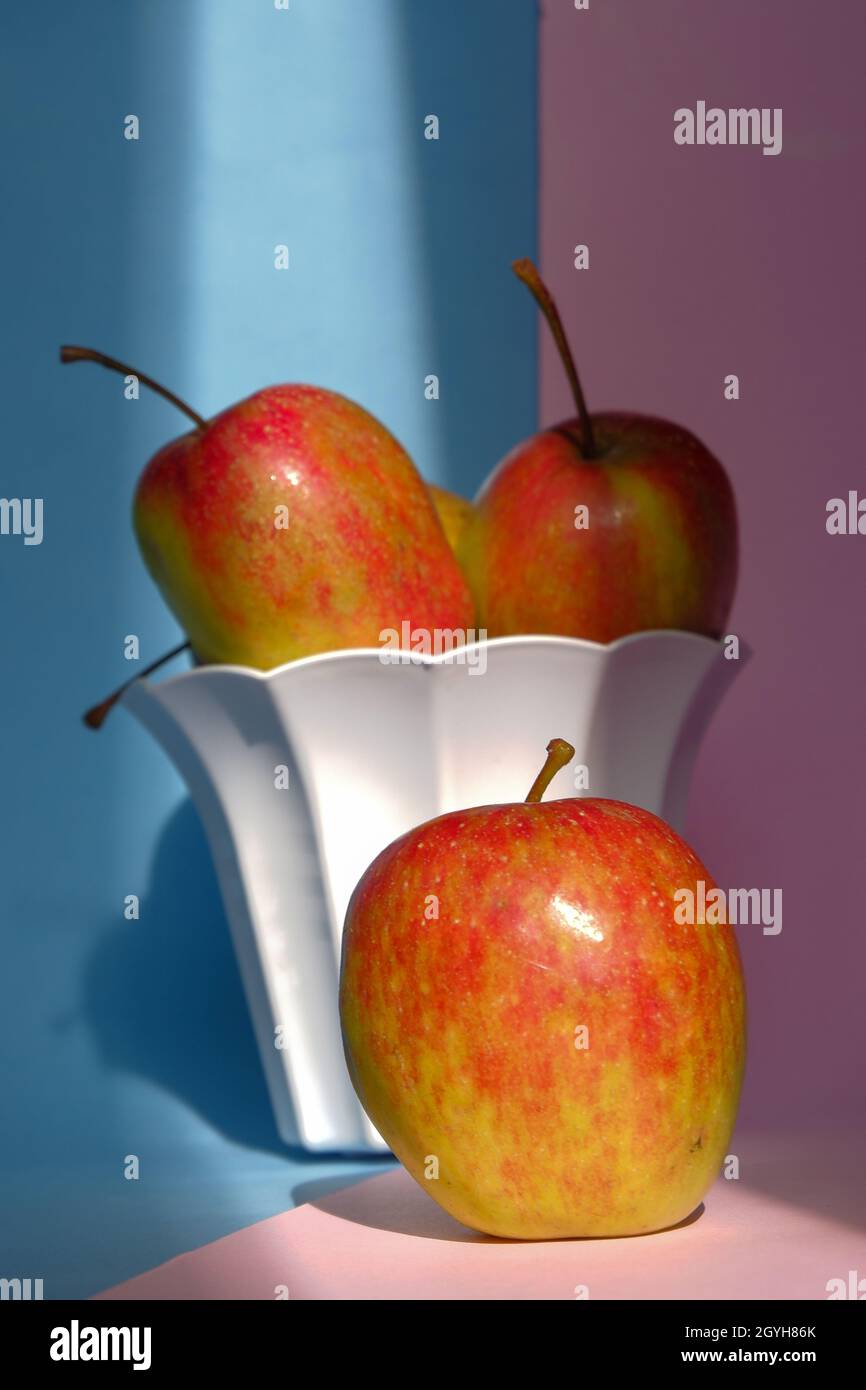 Vertical shot of delicious apples on a pink and blue background Stock ...