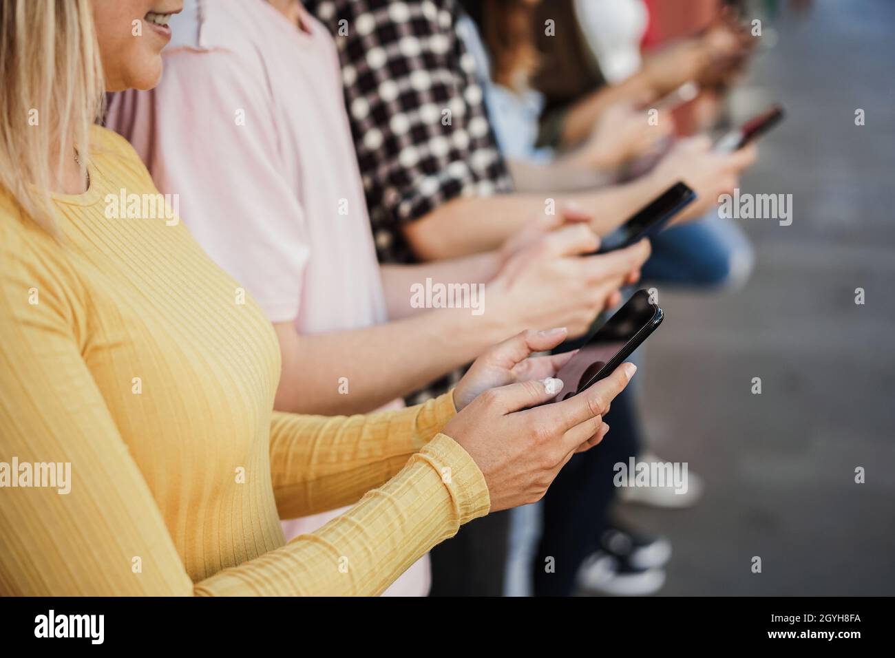 Young happy people using mobile phones outdoor - Focus on left girl ...