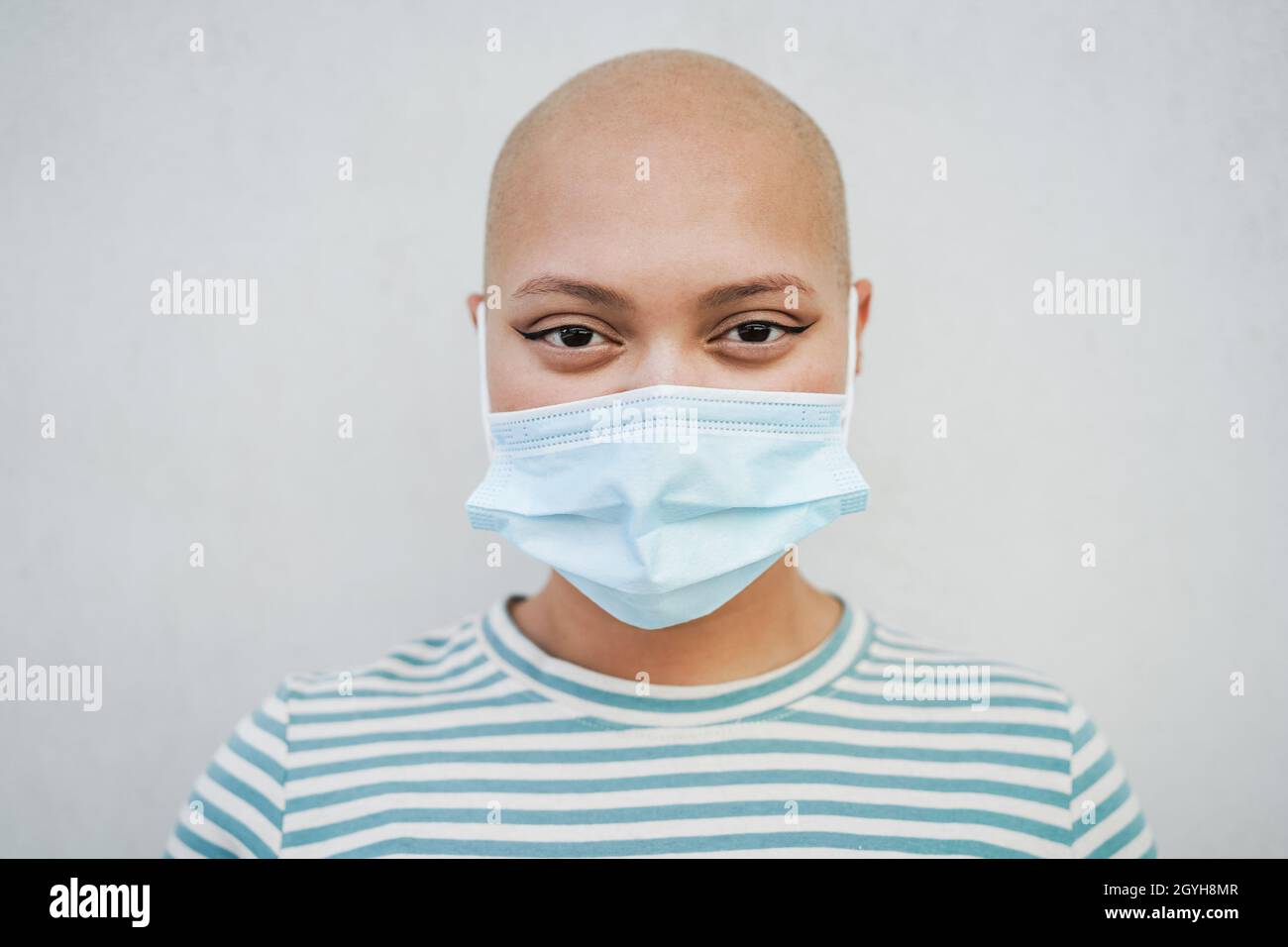 Bald girl posing in front of camera with yellow background - Focus on ...
