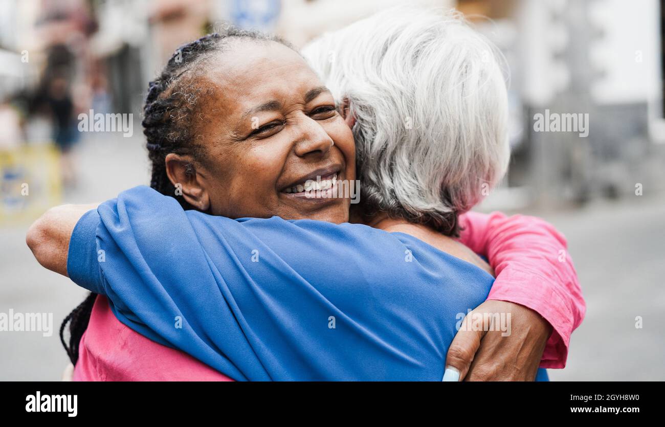 Senior multiracial women meeting and hugging each other outdoor Stock ...