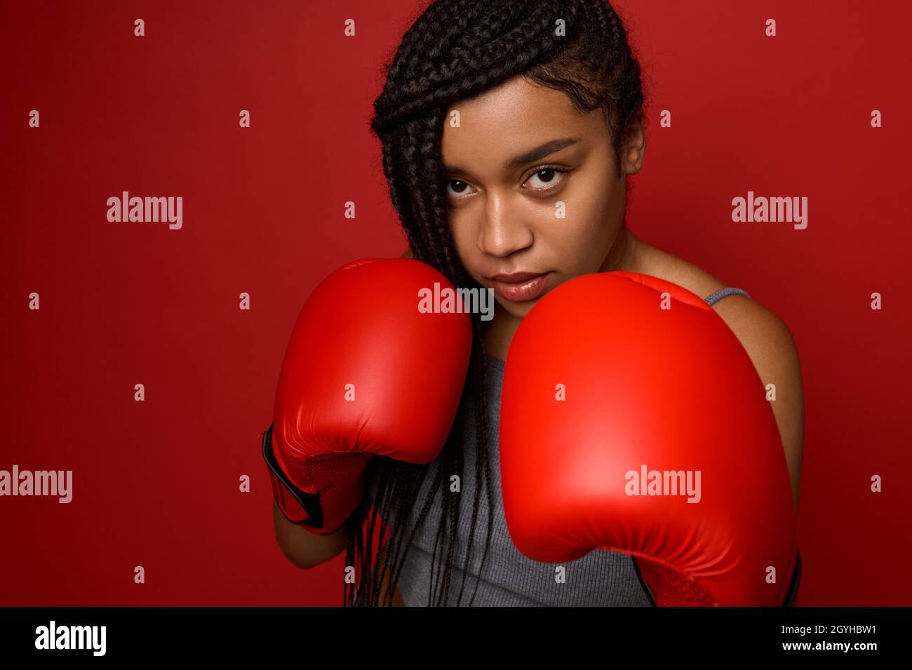 Close-up portrait of concentrated young African sports woman boxer ...