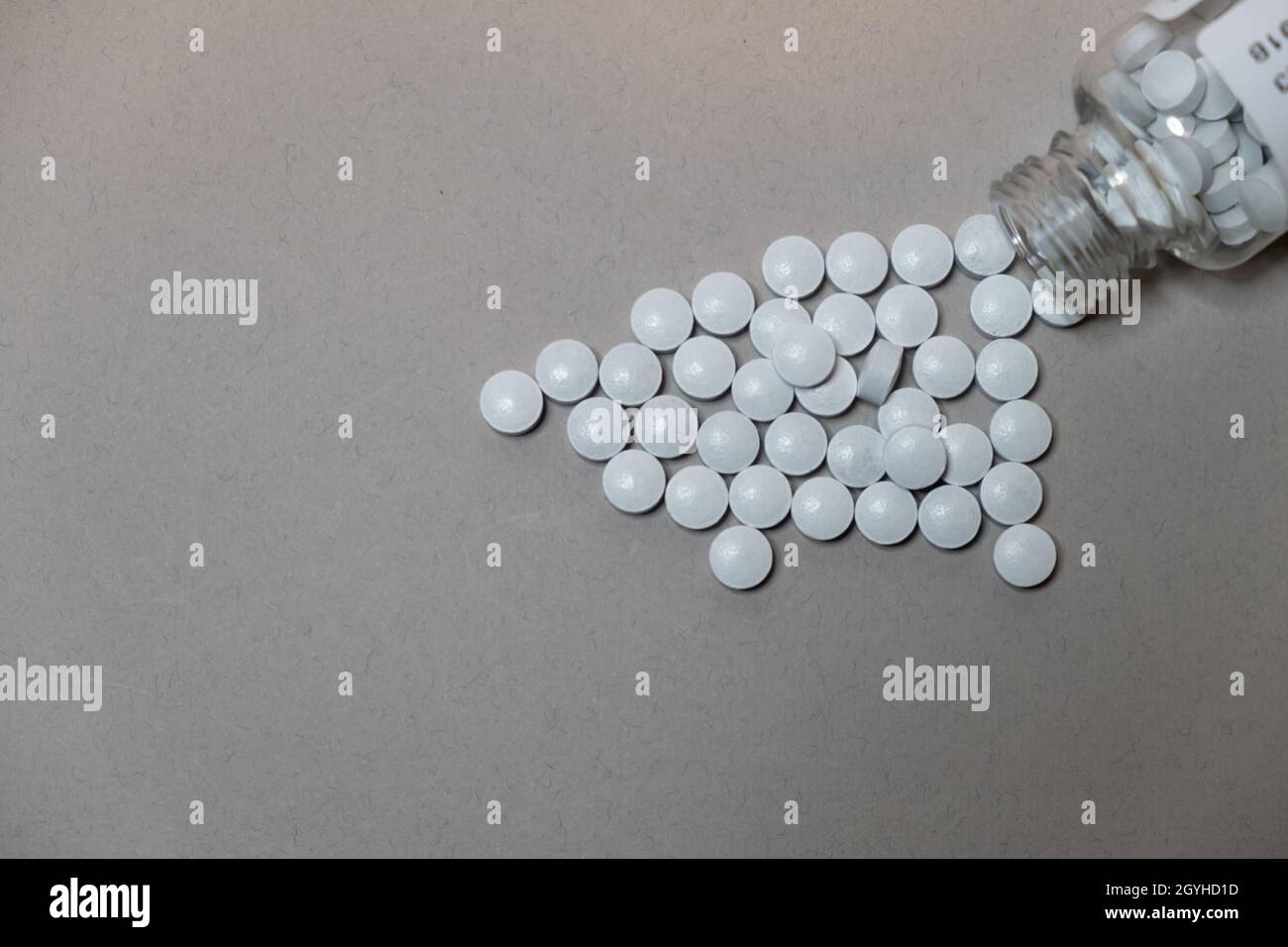 White tablet pills on a flat background with copy space. For ...