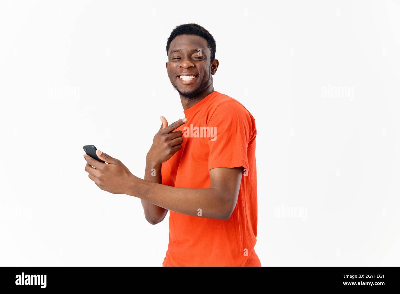 handsome guy of african appearance smiles and holds a mobile phone in ...