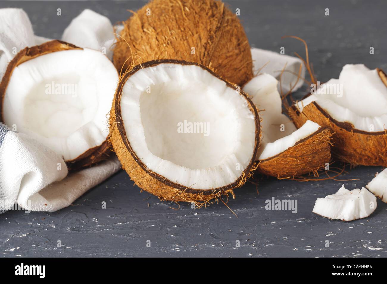 Pile of broken coconuts on ripped grey background Stock Photo - Alamy