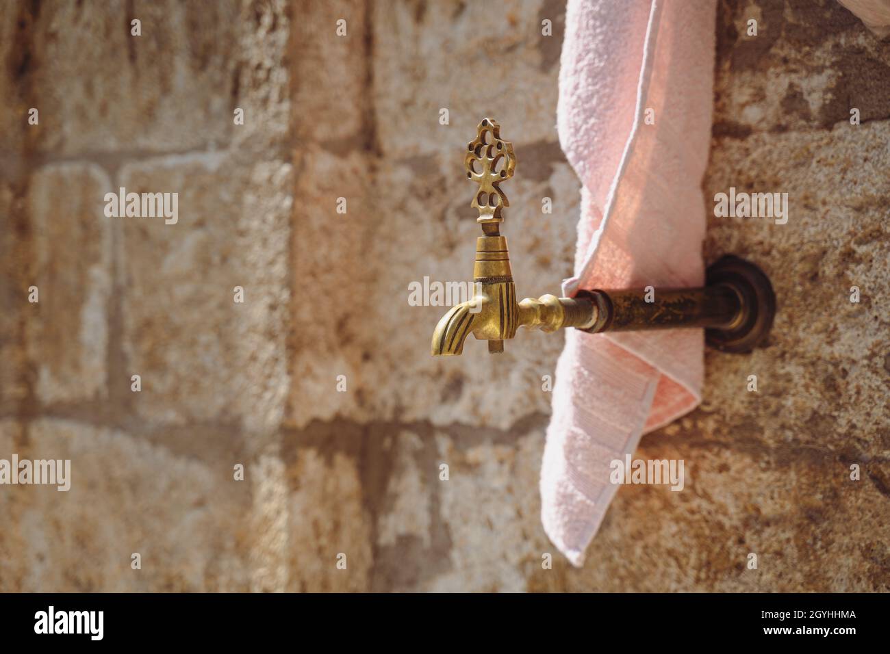 closeup of vintage bronze water faucet with decorated tap and bath ...